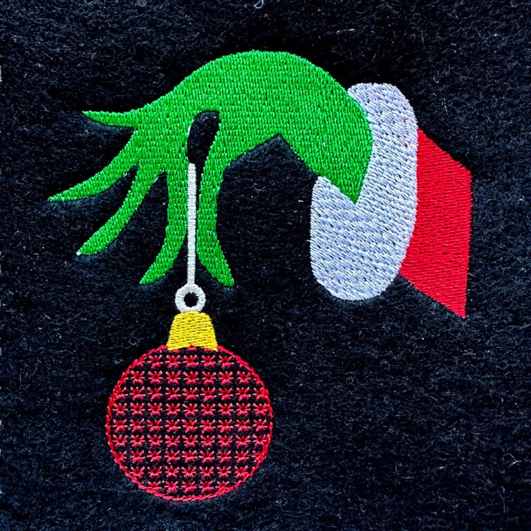 Grinch hand holding ornament - Machine Embroidery Geek